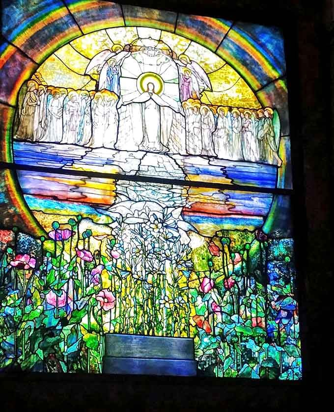 Tiffany's "Flight of Souls" stained glass window transforms sunlight into a divine spectrum of colors inside Wade Chapel.