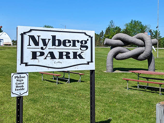 Welcome to wonder! The Nyberg Park sign stands beside a knotted metal sculpture, inviting curious travelers into this roadside attraction.