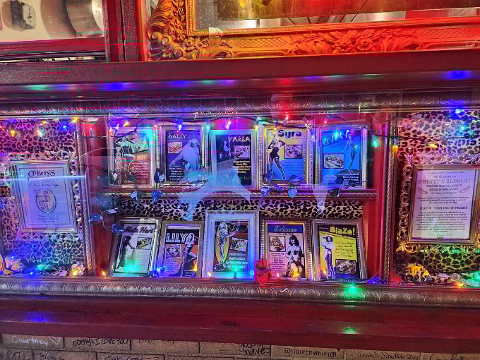 Colorful lights illuminate the burlesque-themed display case. These vintage cards and memorabilia connect hot dogs to their vaudeville-era popularity&mdash;history you can eat!