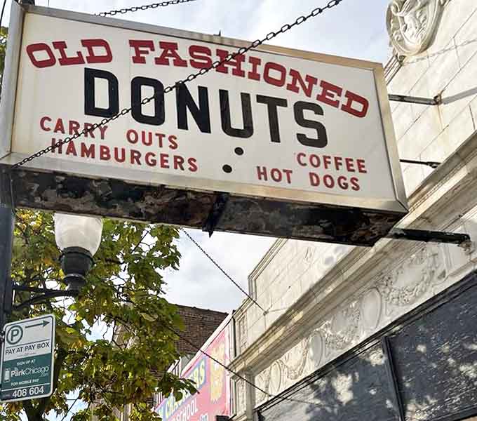 The sign that launched a thousand cravings, hanging proudly above Michigan Avenue like a sugary North Star for hungry travelers.