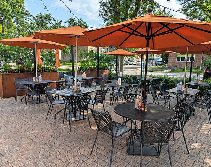Orange umbrellas create a vibrant oasis where Minnesota summers and Southern flavors come together under open skies.