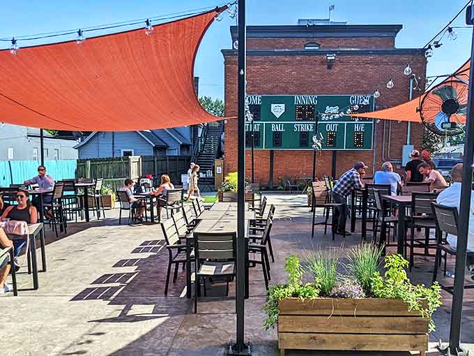 The outdoor patio, complete with scoreboard and shade sails, offers a perfect summer spot to enjoy pizza and root beer under Michigan skies.