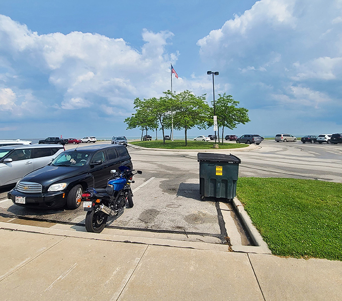 The museum's spacious parking area welcomes visitors from across the Midwest, with the American flag standing tall against clear blue skies.