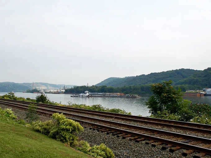 Where the mighty Ohio River curves between green hills, carrying barges, memories, and the commerce of America's heartland.
