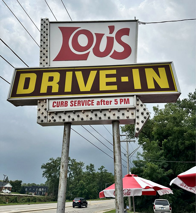 The vintage Lou's Drive-In sign stands tall against the Illinois sky, a beacon for those seeking authentic flavor in an increasingly homogenized world.