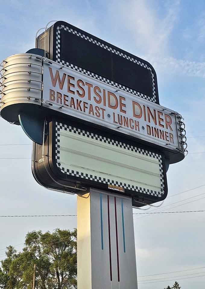 The West Side Diner sign glows against the Michigan sky, a beacon for hungry travelers and locals seeking a taste of authentic Americana.
