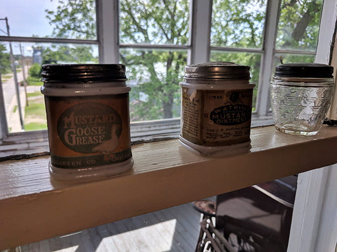 Mustard Goose Grease jars line the windowsill – products whose purposes are forgotten but whose charming packaging remains eternally appealing.