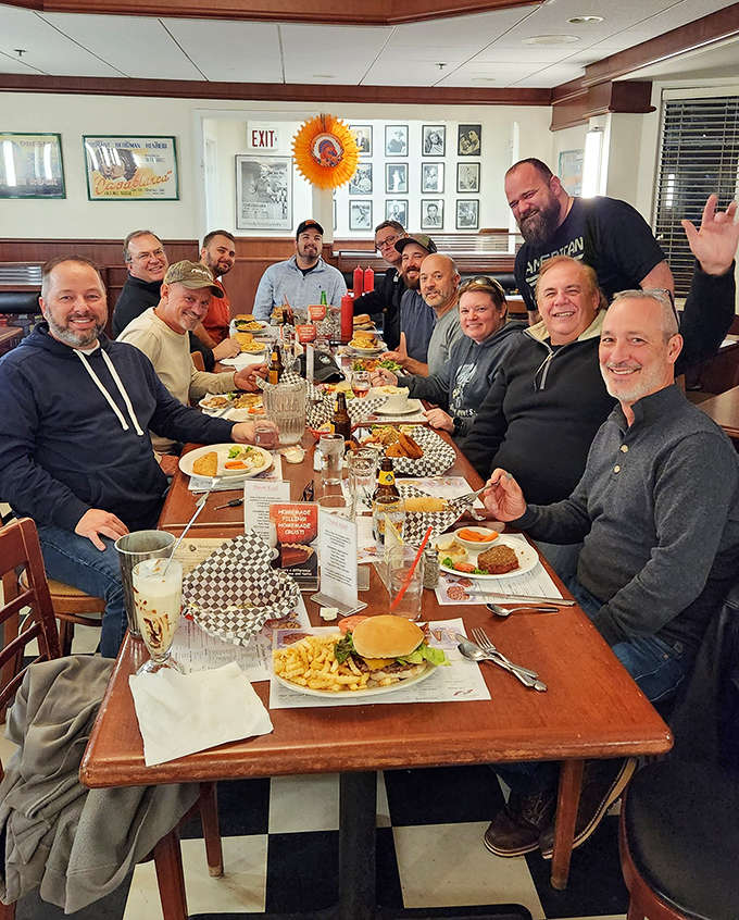 Happy diners gather around tables laden with comfort food classics &ndash; proof that good company and great food never go out of style.