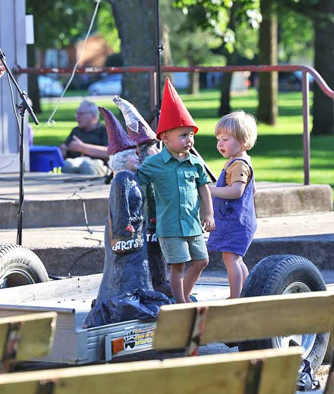 Young visitors delight in discovering gnome statues throughout town, sometimes donning red hats themselves to join in the magical fun.