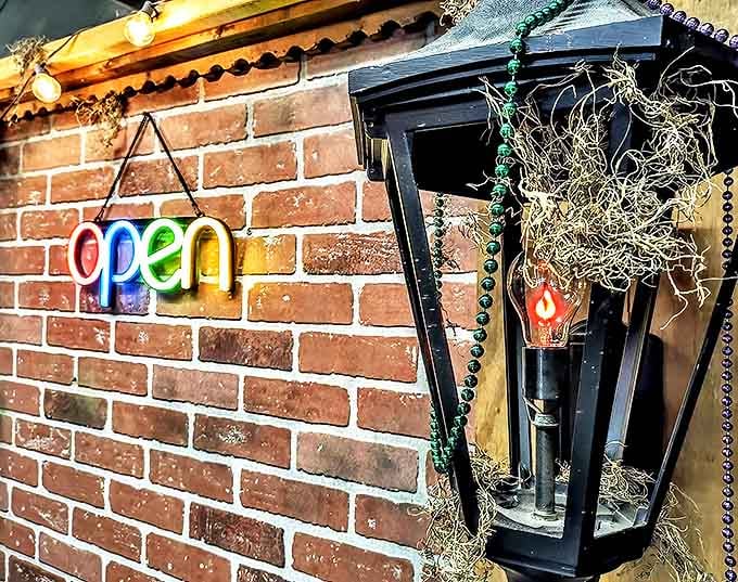 The neon "open" sign glows like a beacon for the curious, while Mardi Gras beads drape the vintage lantern in festive funeral attire.