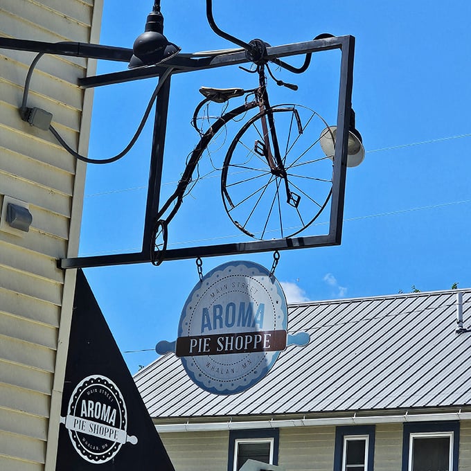 The vintage bicycle sign hanging above the entrance serves as both charming decor and a beacon for hungry cyclists on the trail.