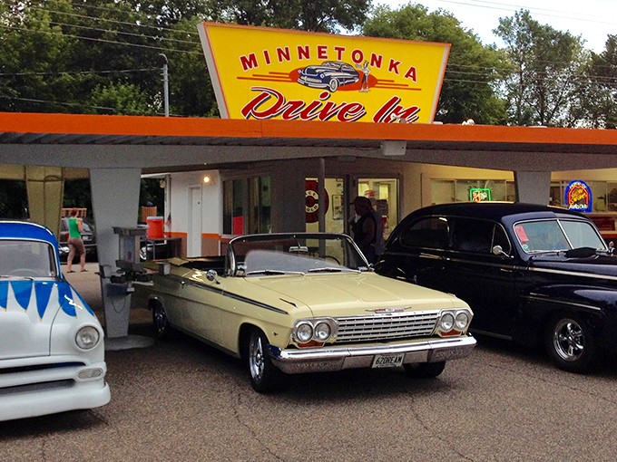 Classic cars shine beneath Minnetonka Drive In sign, blending retro charm, great food, and friendly Spring Park, Minnesota memories tonight.