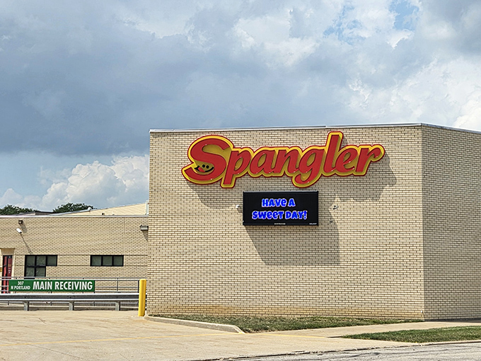 The Spangler factory exterior showcases the company's proud heritage with its iconic logo, where millions of lollipops begin their journey to candy dishes worldwide.