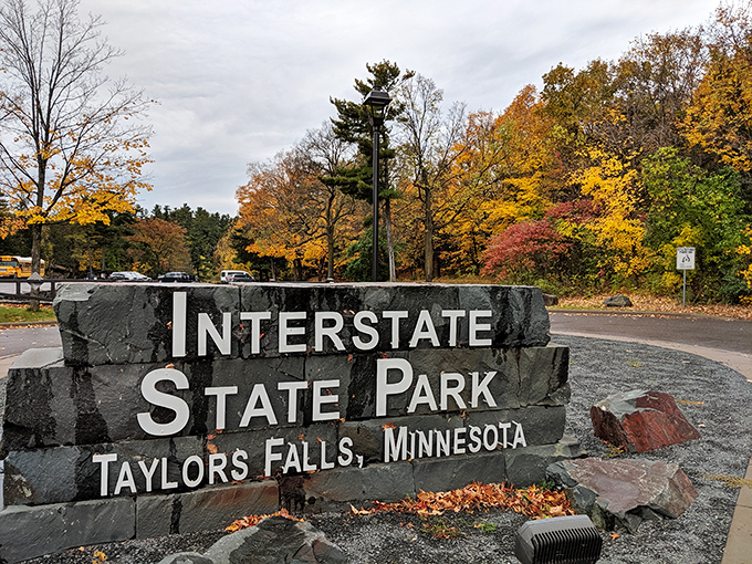 The park's iconic entrance sign stands framed by autumn's finest work, welcoming visitors to a place where state borders matter less than natural beauty.