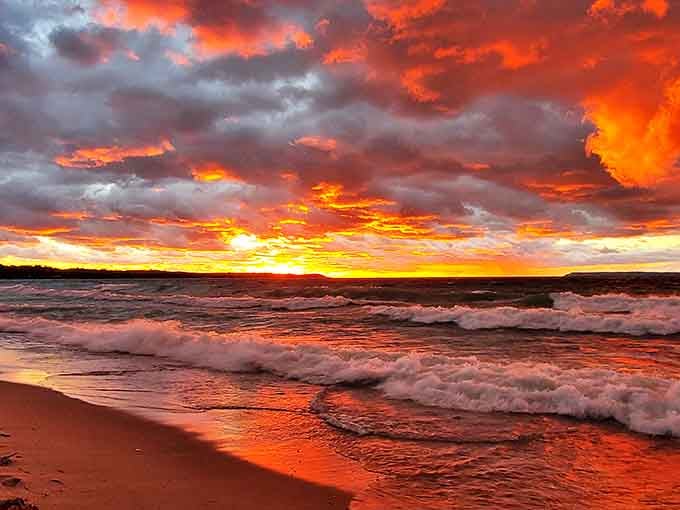 Sunset paints Lake Street Beach in fiery hues, transforming Michigan's shoreline into a magical canvas that rivals tropical paradises.