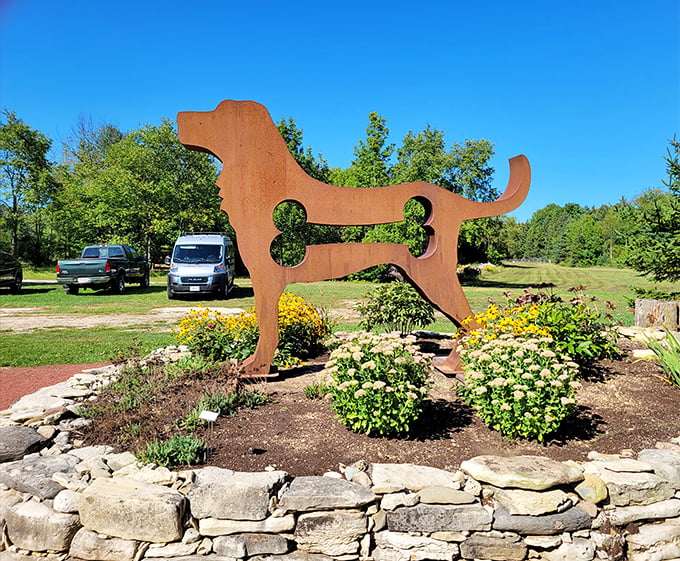This playful metal dog sculpture with bone cutout seems ready to bound across the garden &ndash; man's best friend immortalized in rust.