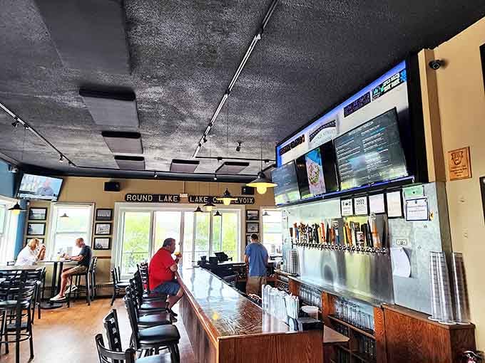 Inside, the polished bar stretches invitingly beneath industrial-chic lighting, while windows frame postcard-worthy views of Round Lake that make every seat the best in house.