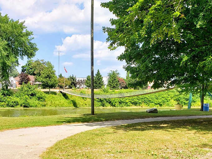 Nature frames this engineering marvel perfectly, as sunlight dances through the cables and reflects off the calm waters below.