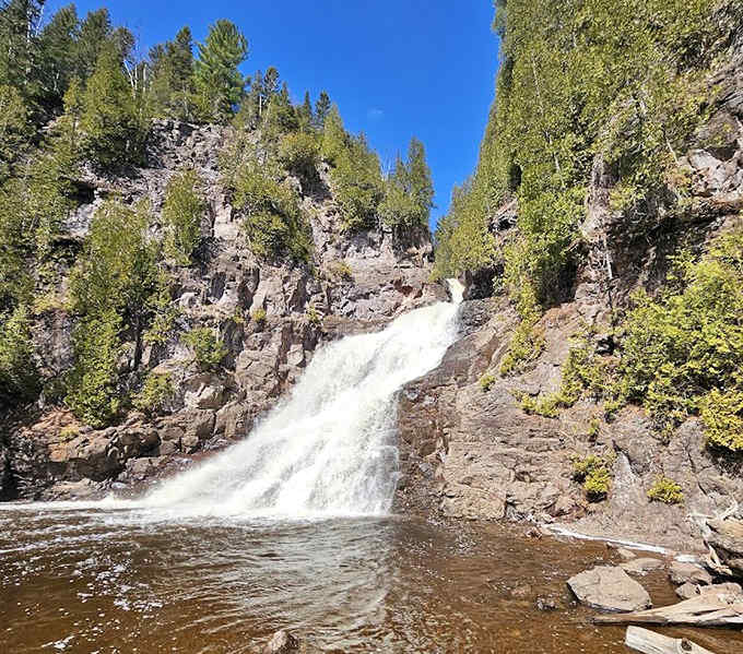 From this angle, you can appreciate how the waterfall splits into multiple channels before reuniting in the crystal-clear pool below.