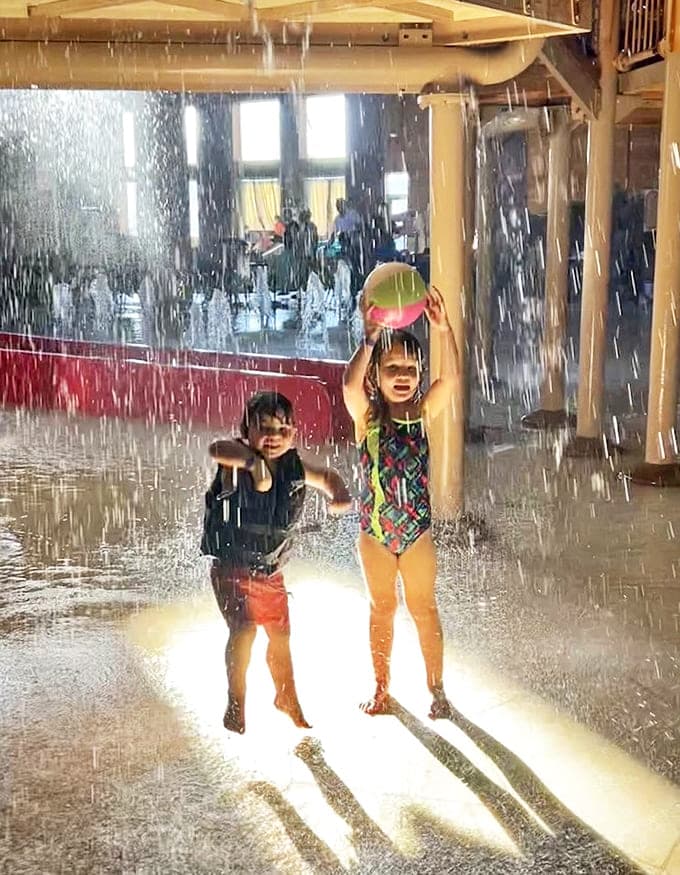 Childhood joy captured in motion &ndash; these little water warriors embrace the deluge from above, proving that getting soaked is half the fun.
