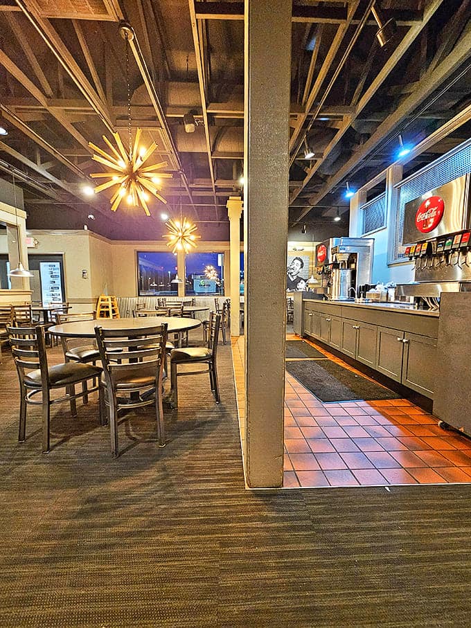 Modern starburst lighting and exposed ceiling create an atmosphere that's both industrial-cool and comfortably inviting. Burger ambiance perfection!