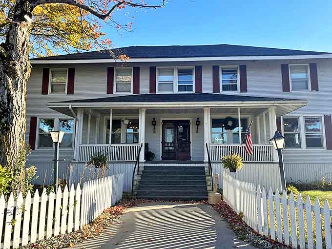 Morning light bathes the historic fa&ccedil;ade, highlighting the distinctive red shutters and welcoming steps that have greeted guests for generations.