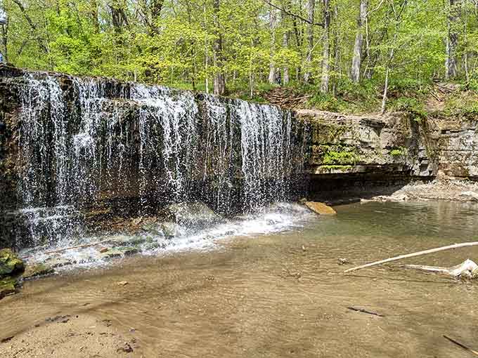 Water cascades over layered rock like nature's own fountain display, proving that sometimes the best things really are worth the hike to discover.