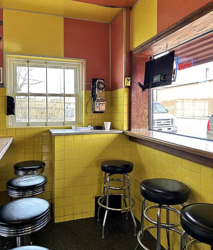 Yellow tile walls and chrome stools create a time capsule atmosphere where conversations flow as freely as the coffee.