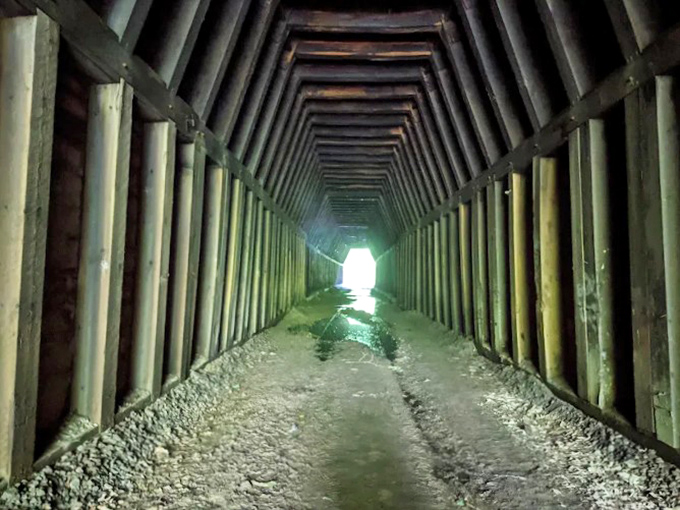 Inside: Wooden ribs line this subterranean passage like the skeleton of a sleeping giant, with light teasing from the distant exit.