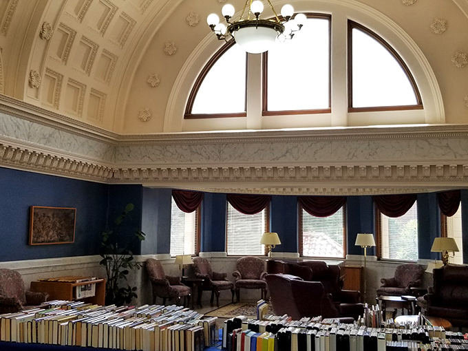 Beneath a soaring domed ceiling, the main reading room invites visitors to sink into plush chairs and lose themselves in literary worlds, surrounded by blue walls and marble elegance.