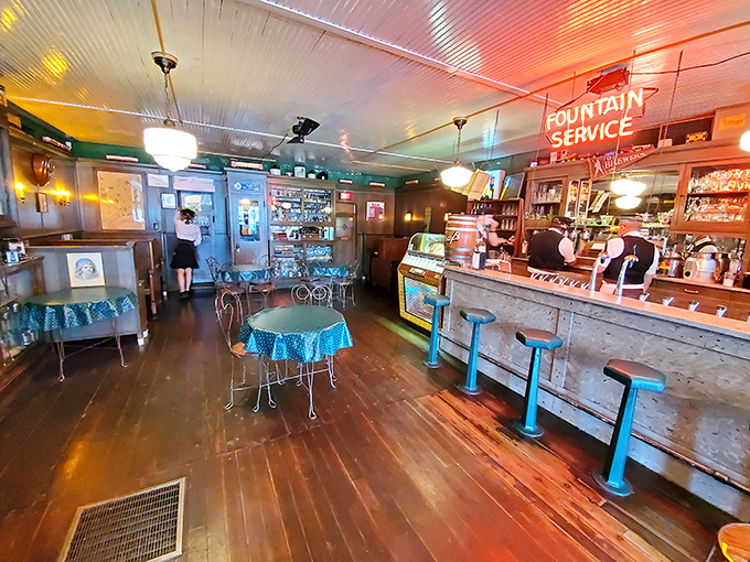 The glowing "Fountain Service" sign illuminates a world of blue-checkered tables and vintage stools where calories don't count.