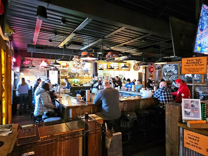 The bustling bar area buzzes with conversation as locals and newcomers alike gather around tables laden with smoky treasures.
