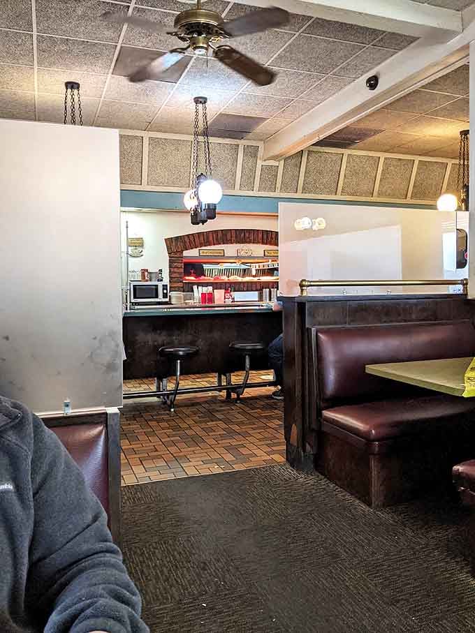 Classic diner ambiance with burgundy booths and hanging lights creates that perfect "where everybody knows your name" vibe that makes breakfast feel like coming home.