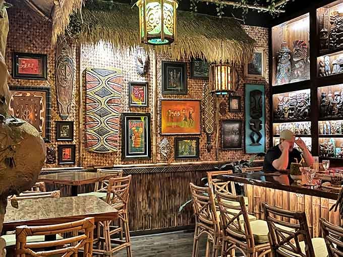 Bamboo walls adorned with tiki art and glowing lanterns create an immersive Polynesian atmosphere that transports you thousands of miles from Michigan.