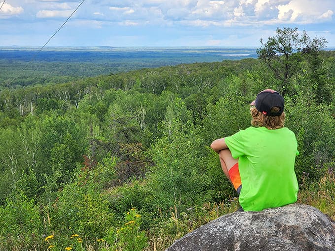 The sweeping landscape unfolds like nature's IMAX screen, with forests stretching to the horizon and Lake Superior shimmering in the distance.