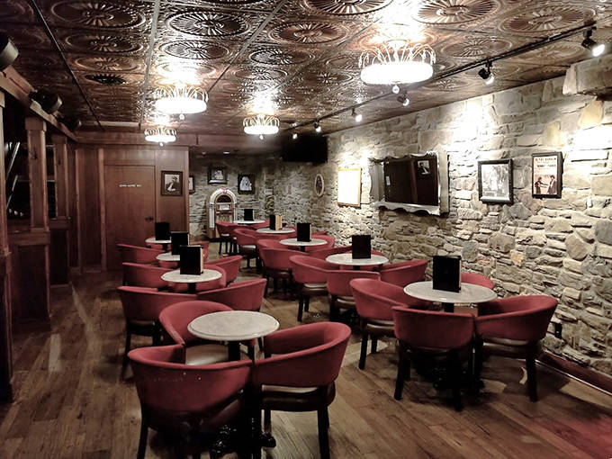 Step into the past with The Mudd Room's intimate stone walls, ornate tin ceiling, and plush red seating &ndash; speakeasy elegance personified.