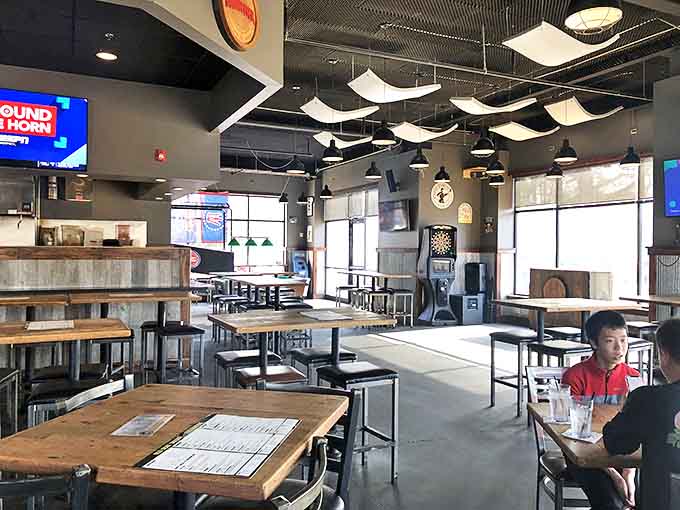 Modern industrial meets cozy tavern vibes, creating the perfect backdrop for the food drama about to unfold on your plate.