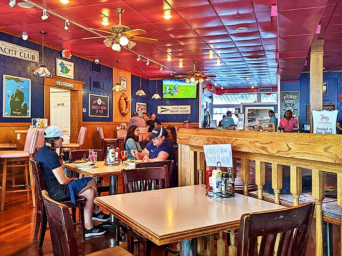 Nautical charm meets cozy comfort inside the Pink Pony, where navy walls and wooden accents create the perfect island dining atmosphere.