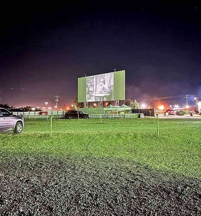 As darkness falls, the massive screen comes alive with flickering images, transforming an ordinary field into movie magic.