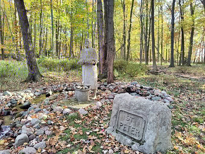 Saint Peter stands sentinel in autumn's golden light, surrounded by a circle of stones like a quiet guardian of this woodland sanctuary.
