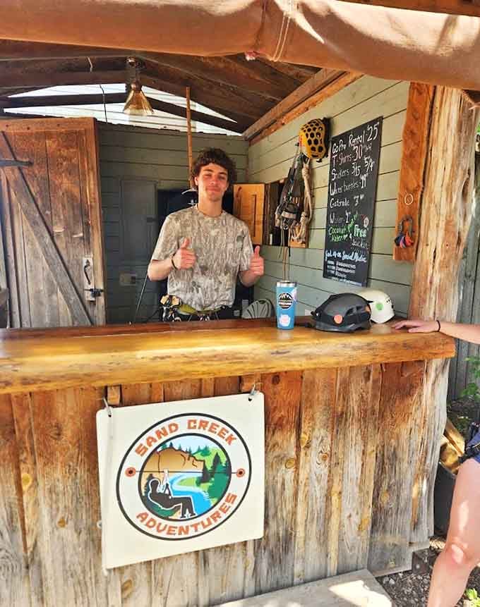 The rustic check-in cabin welcomes thrill-seekers with its weathered charm and promise of adventure waiting just beyond those wooden doors.