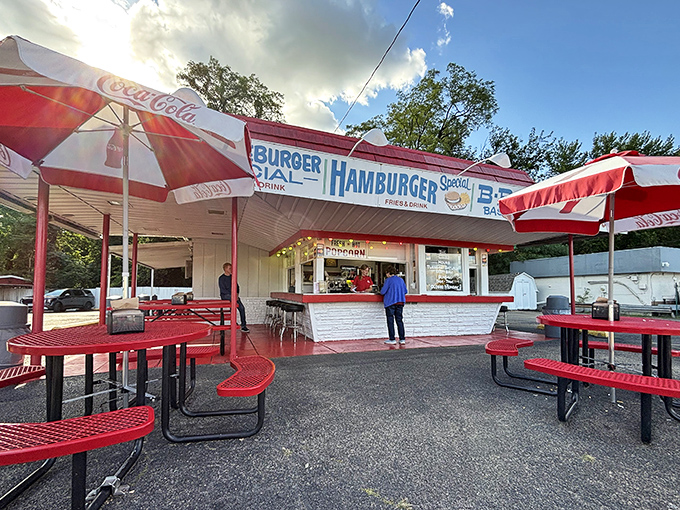 Under Coca-Cola umbrellas, diners gather at Lou's open-air counter, where ordering a cheeseburger feels like stepping into a living Norman Rockwell painting.