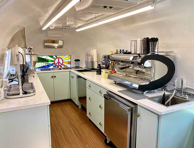 Inside this compact caffeine laboratory, mint-green cabinets and stained glass accents create a surprisingly spacious feel where barista magic happens daily.