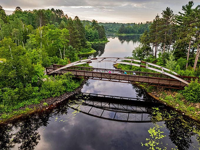 From this bird's-eye view, the Mesabi Trail's elegant bridge spans the water like an artist's brushstroke, connecting landscapes while barely disturbing their natural beauty.