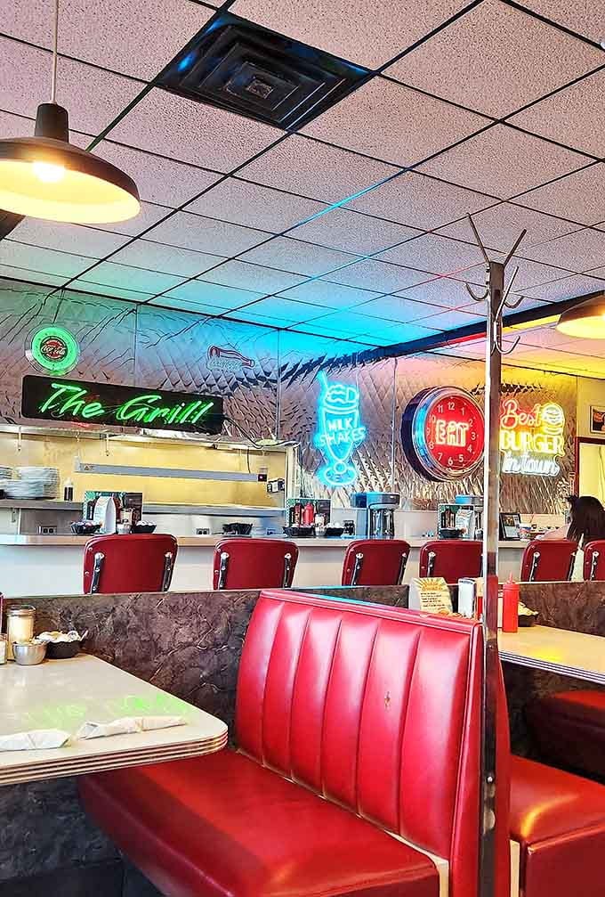 Neon signs illuminate the chrome-trimmed interior where "The Grill" serves up classics under the watchful glow of vintage clocks and memorabilia.