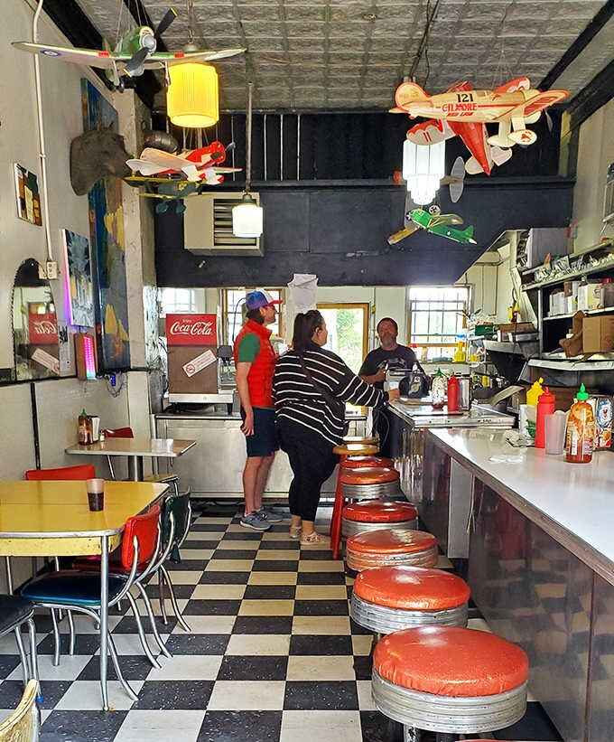 Inside, the classic diner setup features a checkerboard floor and counter seating where customers can watch their meals being prepared with practiced precision.