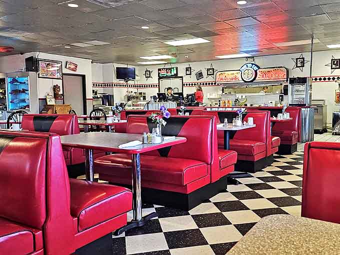 Classic red vinyl booths and checkerboard floors transport diners back to simpler times when conversations happened face-to-face.