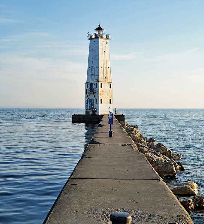 Calm Sea: The lighthouse's reflection stretches across glassy waters, creating that rare perfect moment when Lake Michigan decides to play nice.
