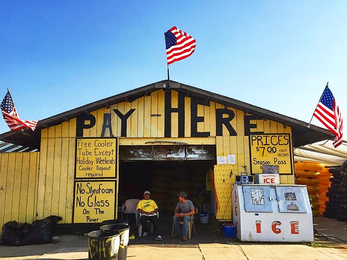 The iconic "PAY HERE" entrance at K & K Tubing stands as a cheerful yellow gateway to river adventures.