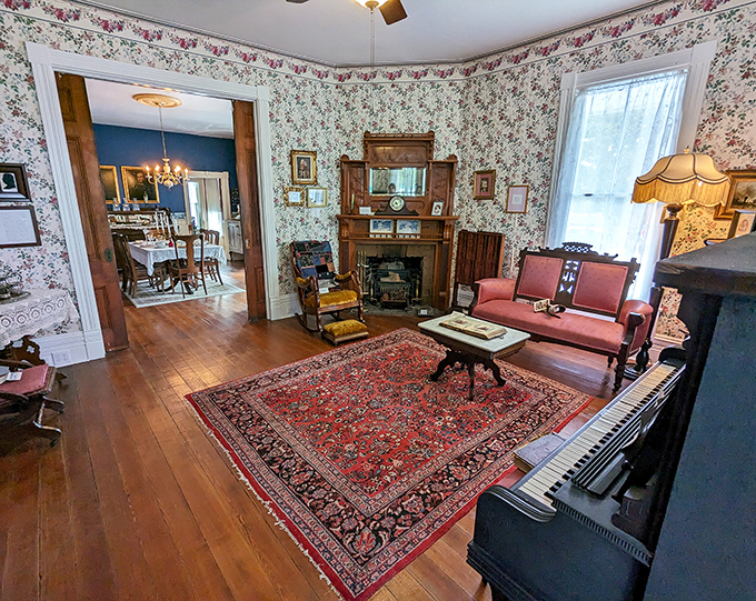 Floral wallpaper, period furniture, and a Persian rug create an authentic Victorian parlor where you can almost hear ghostly whispers of long-ago conversations.
